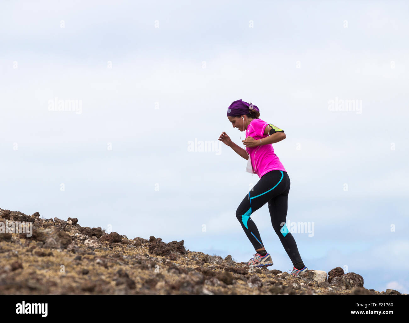 Female runner running uphill on mountain trail Stock Photo - Alamy