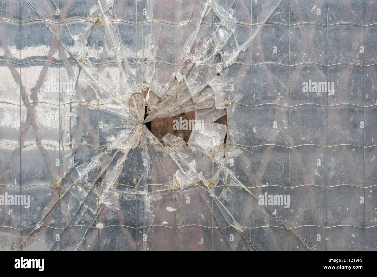 Hole in industrial window glass Stock Photo - Alamy