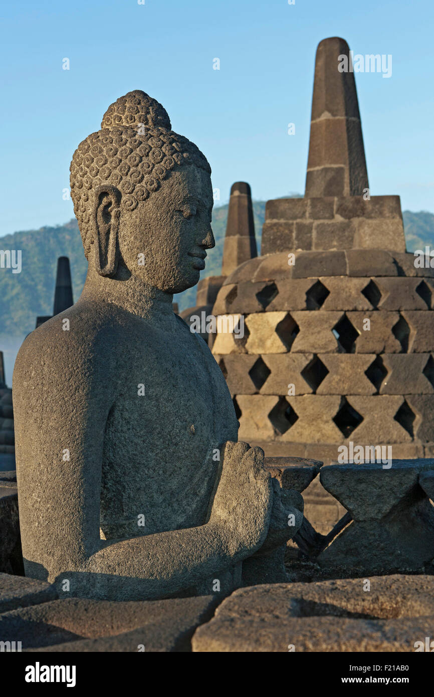 Indonesia, Java, Borobudur, Seated, granite Buddha with small stupas in ...