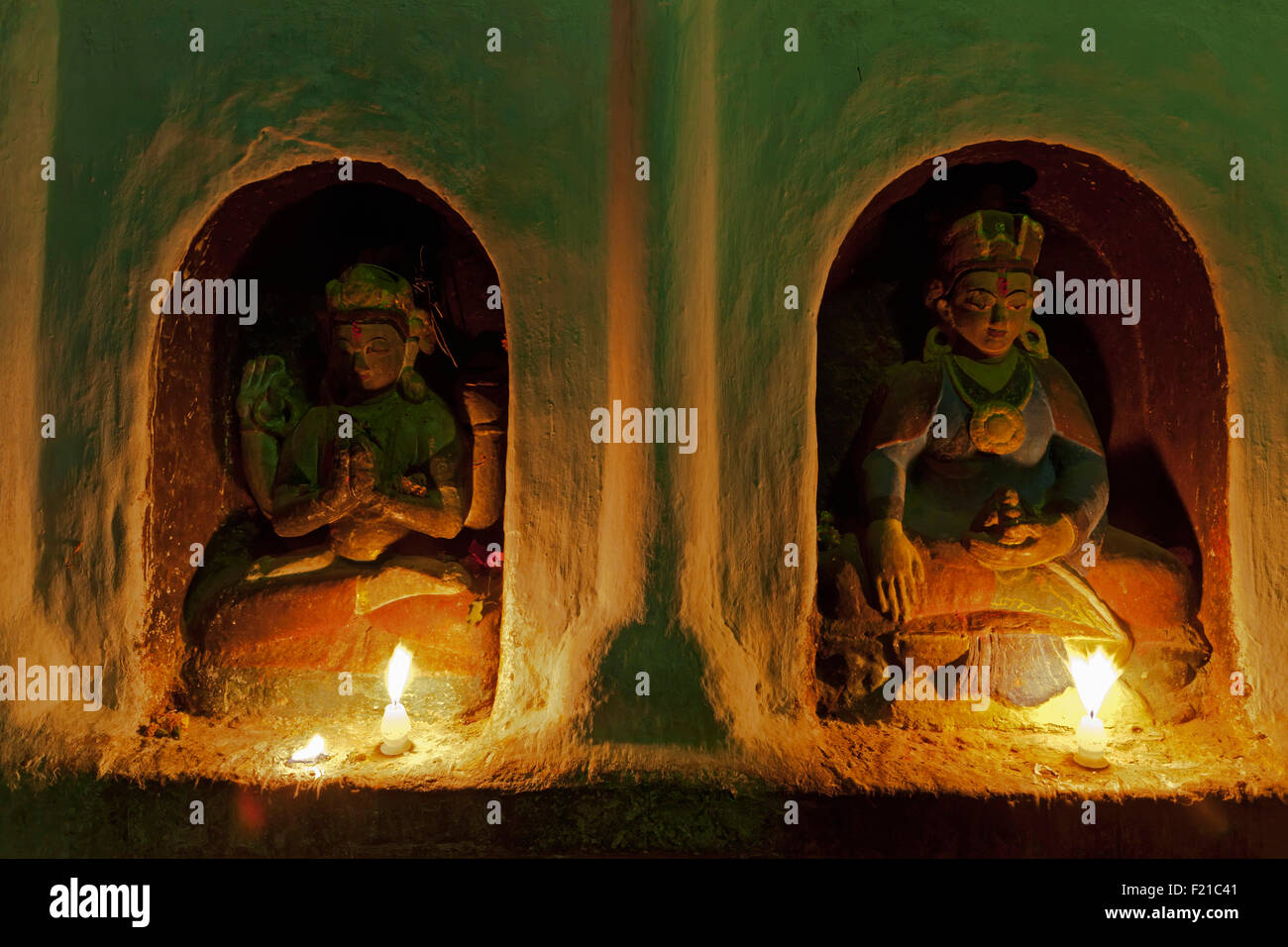 Nepal, Kathmandu, Two small, candle-lit niches in the shrine to Ajima ...
