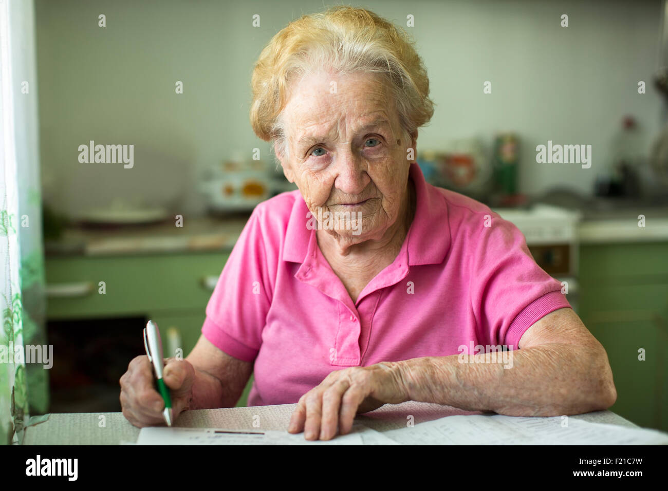 Elderly senior woman populates handle her utility bills notices ...