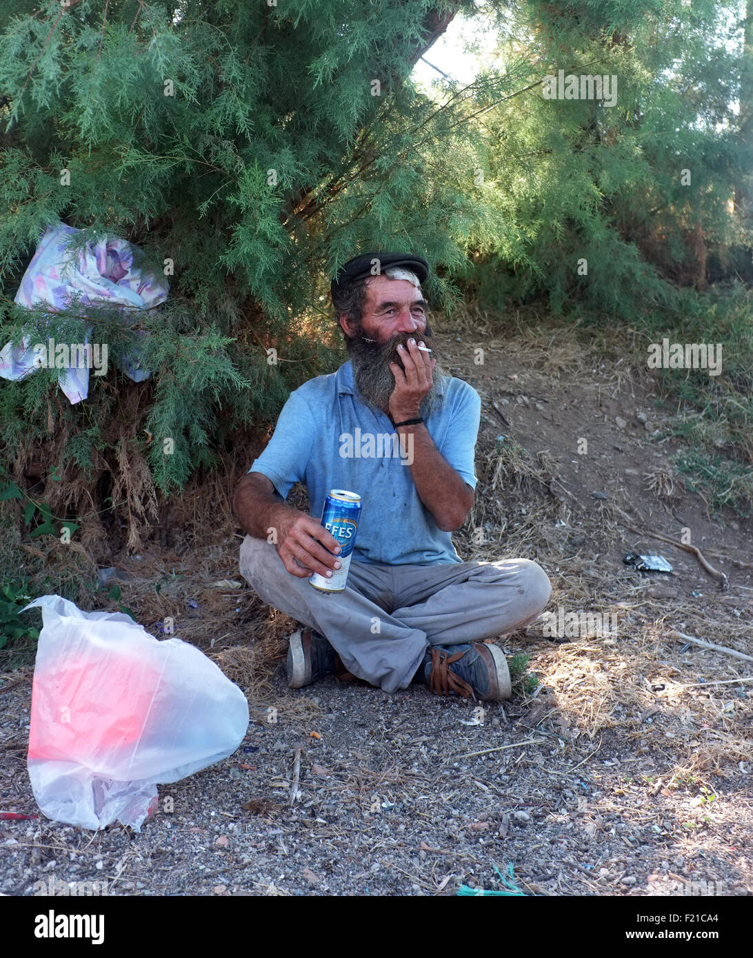 Homeless man smoking and drinking Stock Photo - Alamy