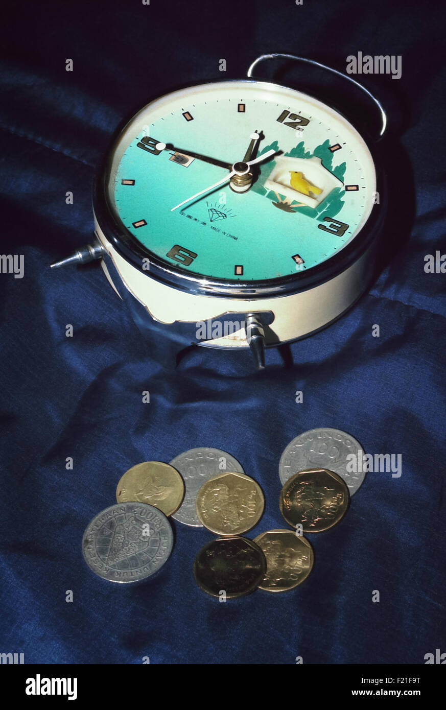Desk clock and coins Stock Photo - Alamy