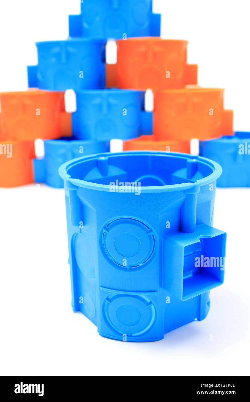 Blue and orange plastic electrical boxes on white background ...