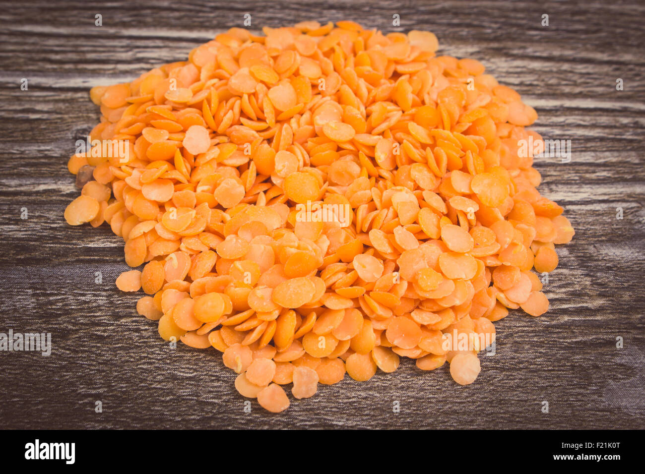 Vintage photo, Heap of raw red lentil lying on wooden background ...