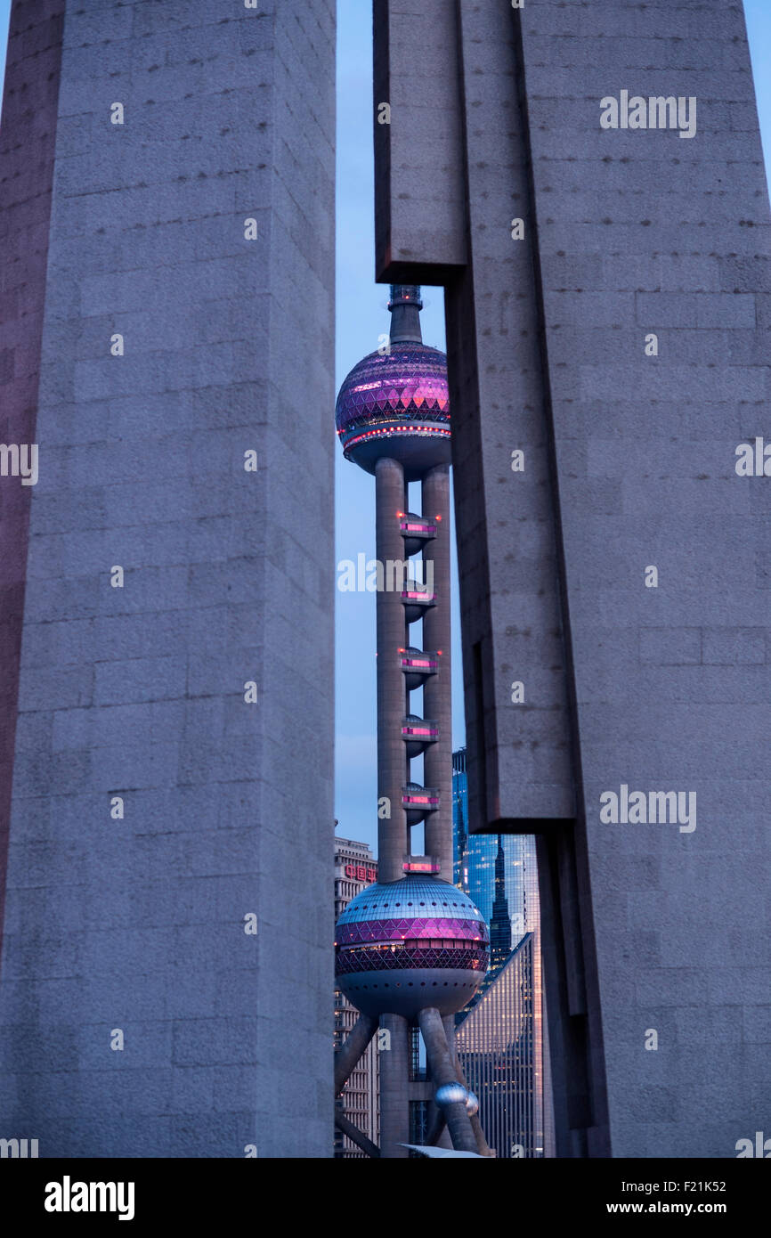 Oriental Pearl Tower seen through towering gray pillars in Shanghai's ...