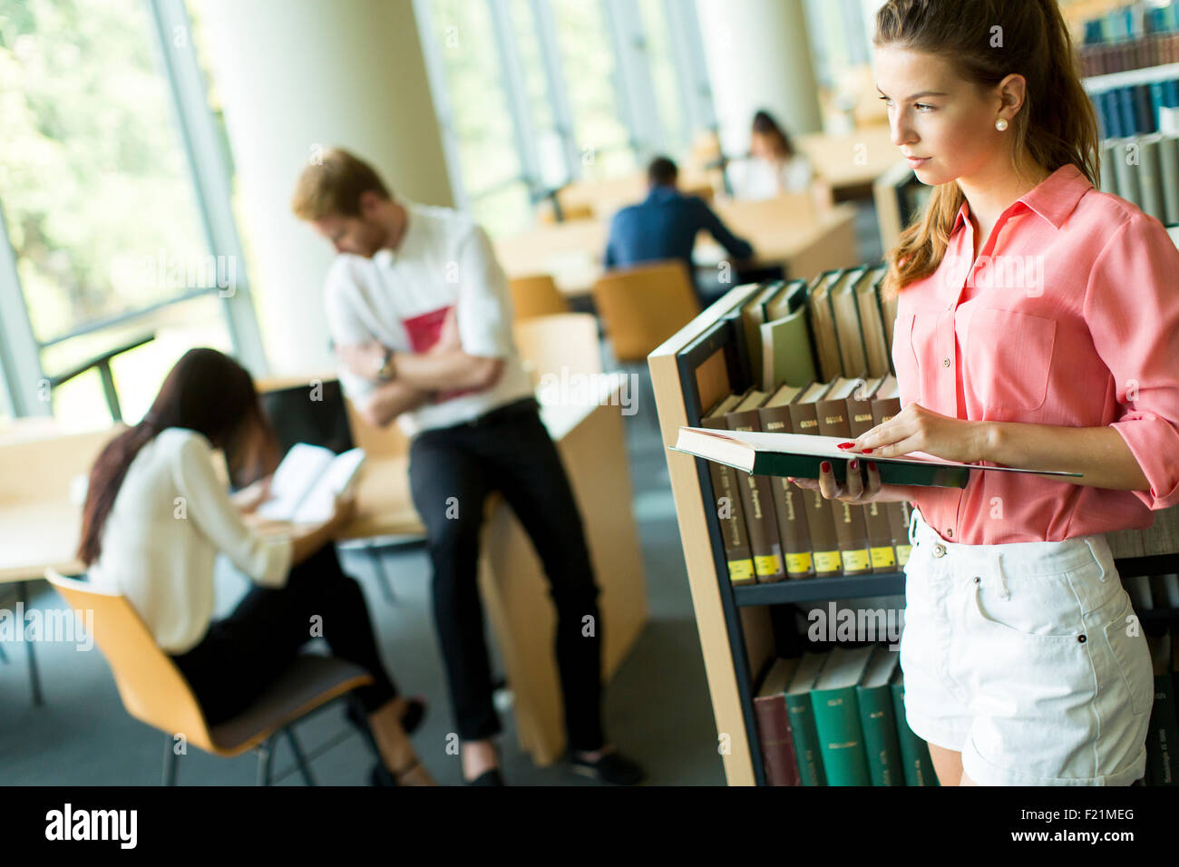 Young woman in the library Stock Photo - Alamy
