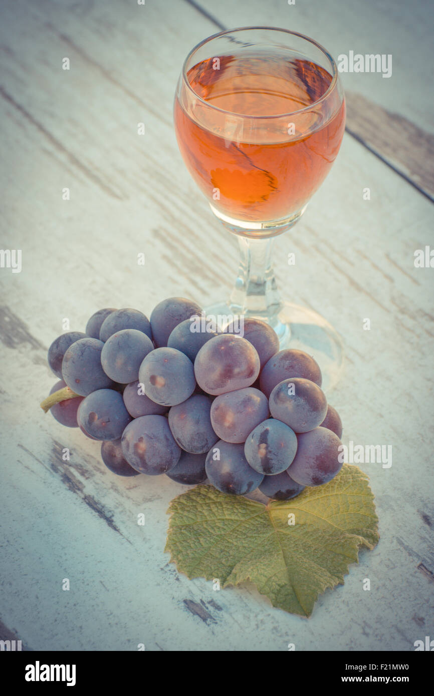 Vintage photo, Bunch of fresh grapes with leaf and glass of wine on old ...