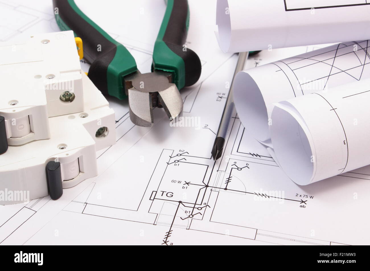 Metal pliers, screwdriver, electric fuse and rolls of diagrams on ...