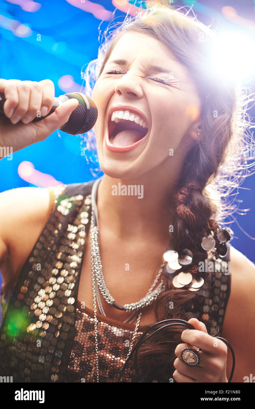 Ecstatic woman singing in mike with her eyes closed Stock Photo - Alamy