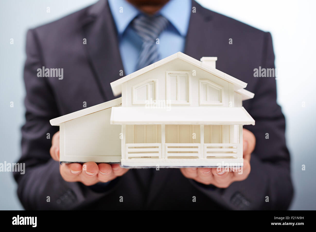 Businessman showing model of new house Stock Photo - Alamy