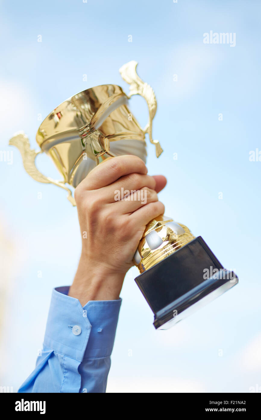 Male hand holding gold award Stock Photo - Alamy