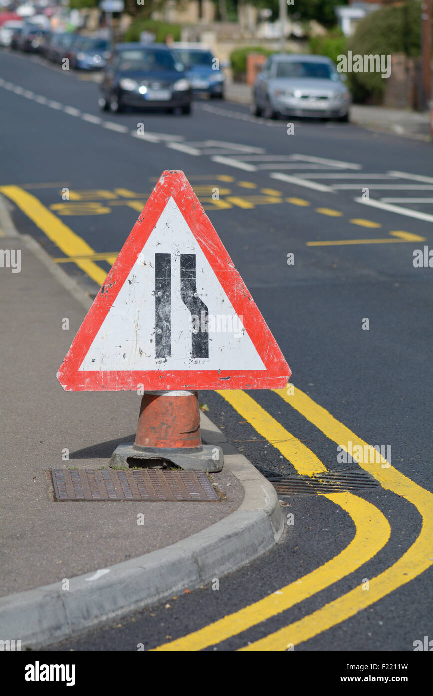 'Road narrows' traffic sign on pavement in town Stock Photo - Alamy