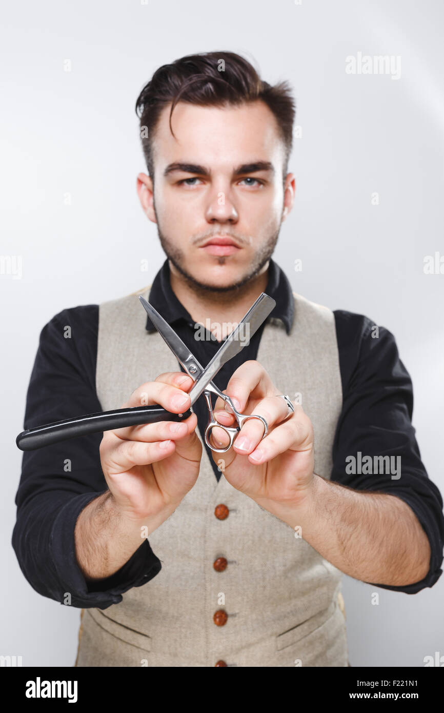 Bearded handsome man posing with vintage razor and scissors, wearing in ...