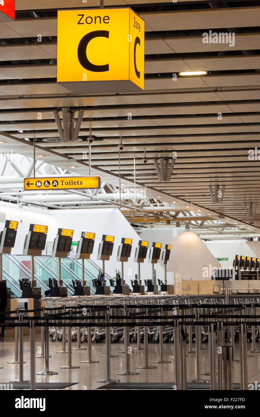 Closed check in desks and zone C sign at Heathrow airport Stock Photo ...
