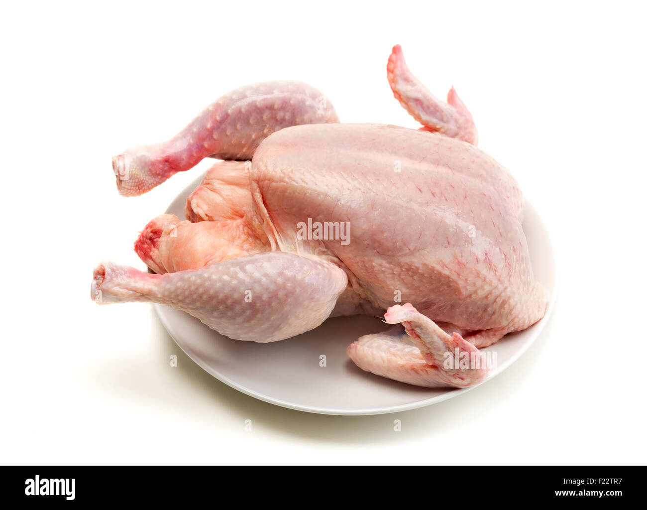 Carcass of broiler chicken on a plate (not cooked). Isolate on white ...