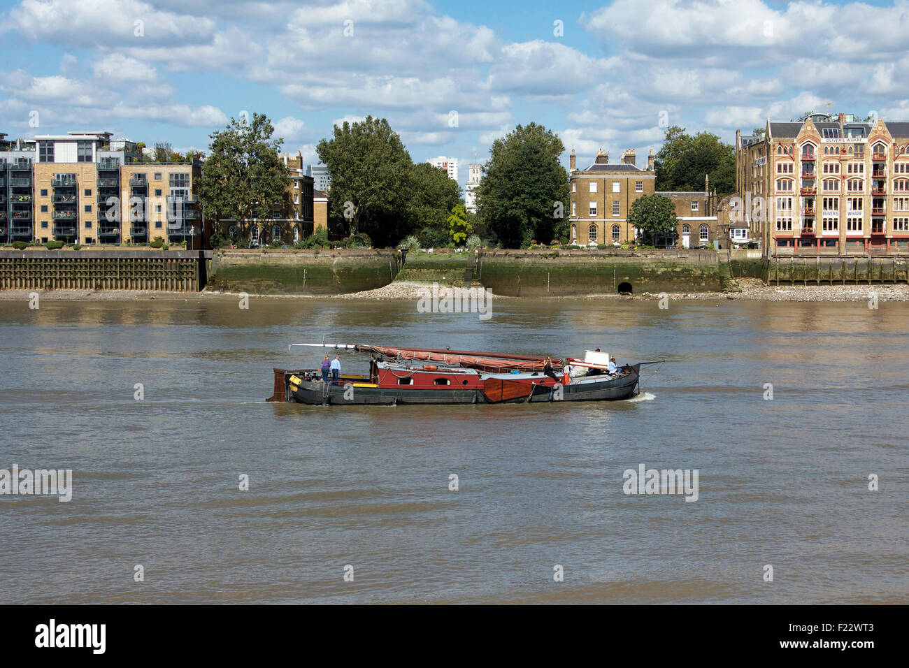 Traditional London barge cruising with its sail folded on the River ...
