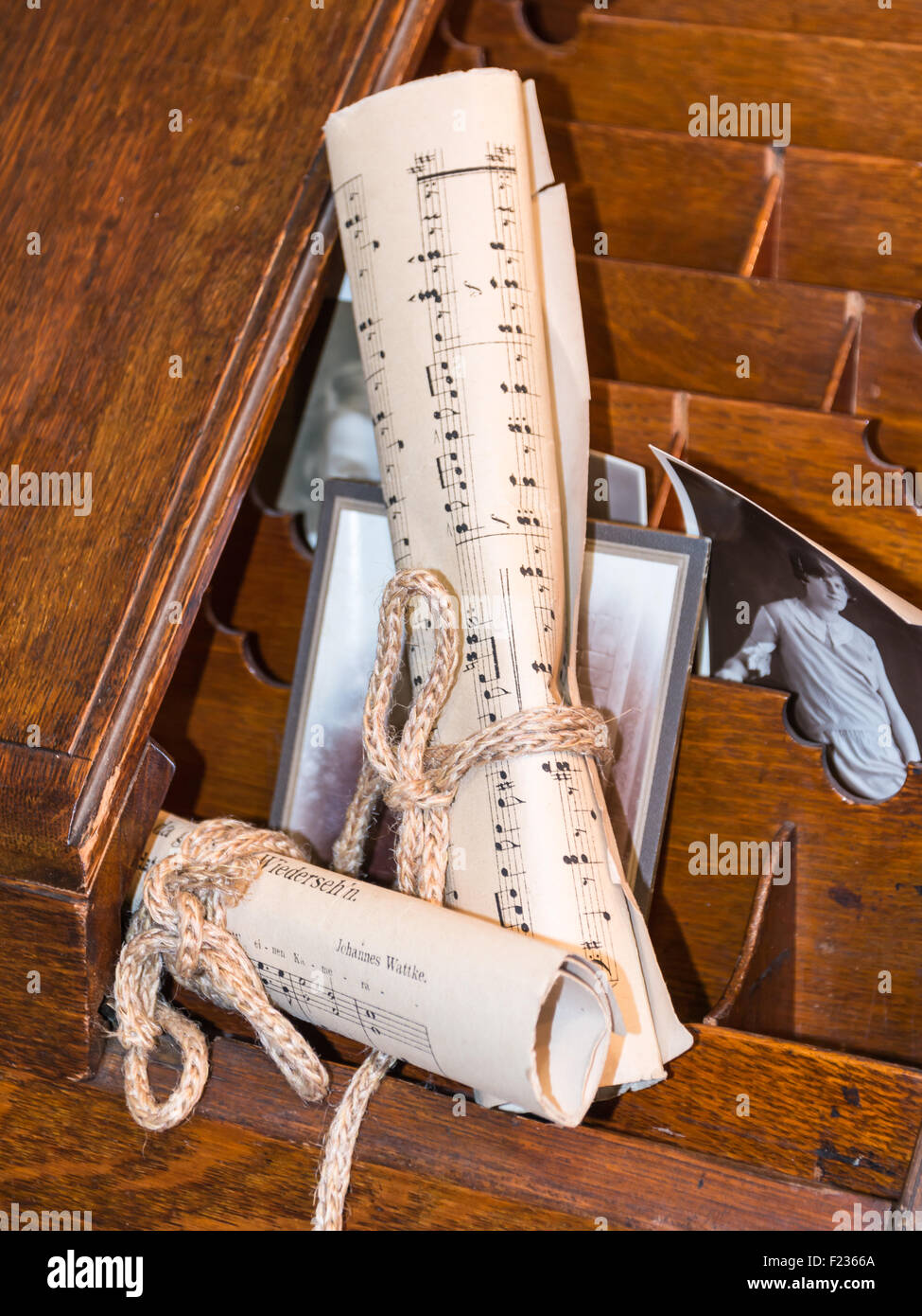 Rolled Music Sheet with aged photo over wooden drawer, composition ...