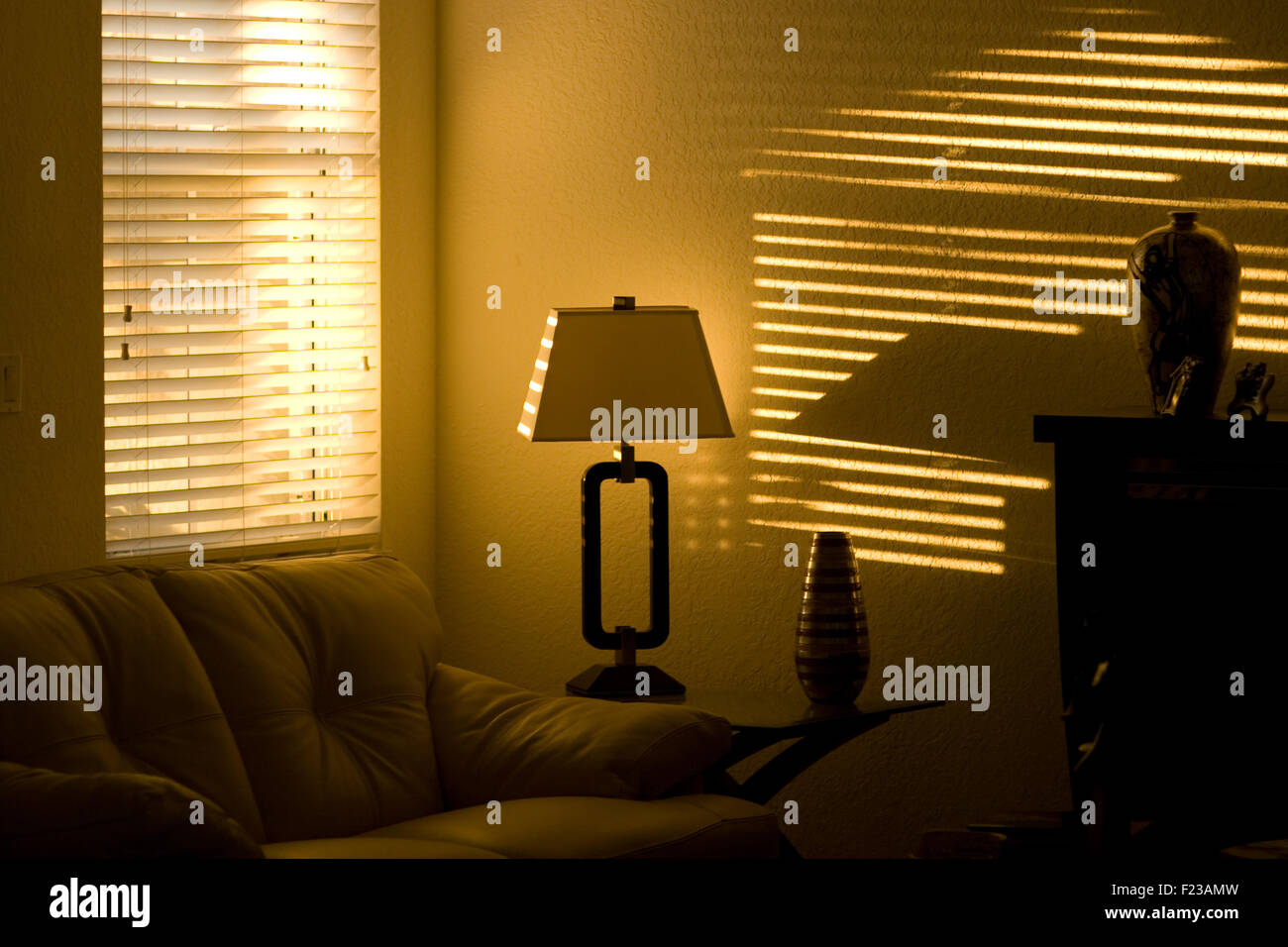 Living room wall illuminated by sunlight at late afternoon through a ...