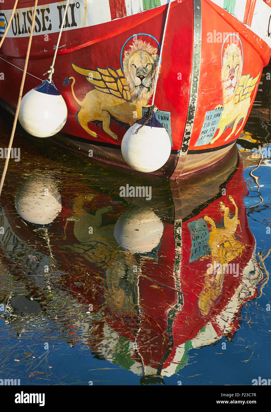 Red boat with two winged lions the symbol of Venice painted on its hull ...