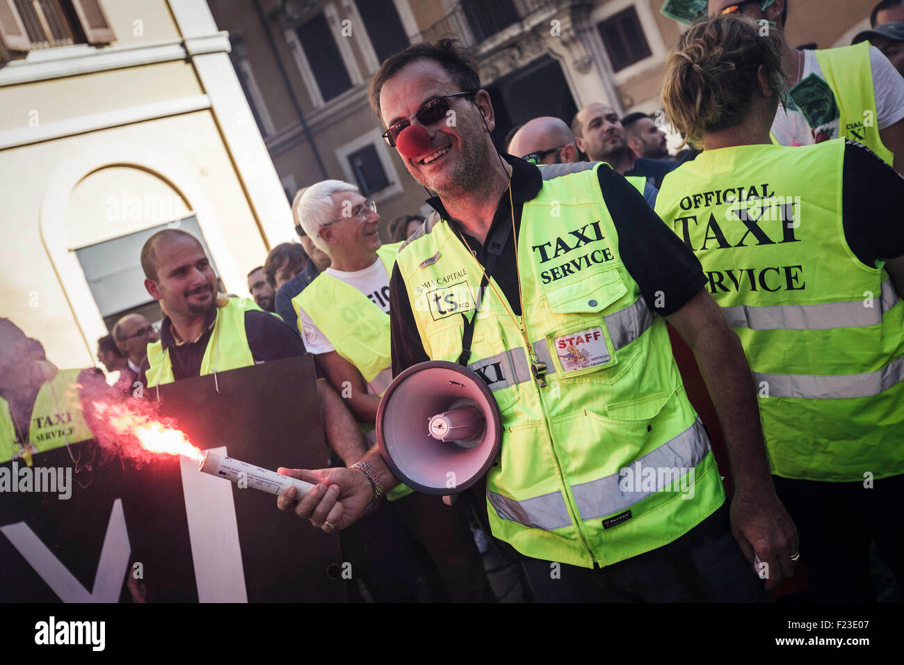 An Italian taxi driver lights a flare as he take part in a ...