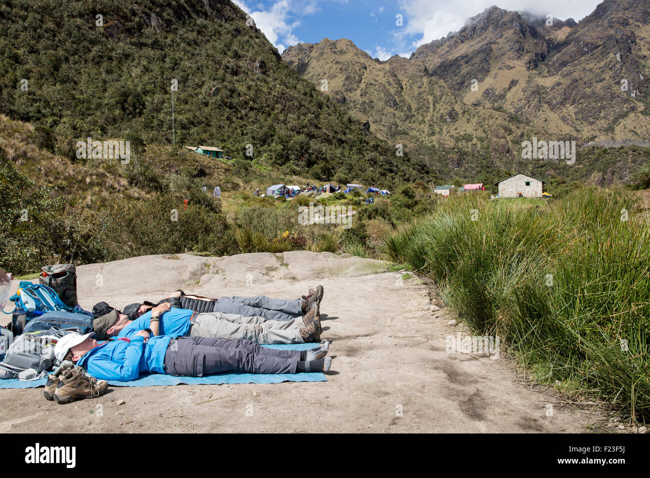 Peru, Backpackers resting in sunshine at campsite near Sayaqmarka ruins ...