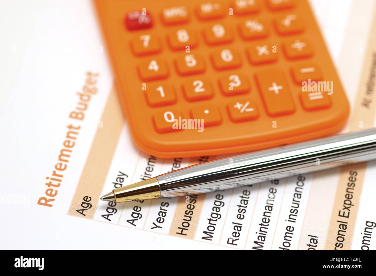 retirement plan document with pen and orange calculator Stock Photo - Alamy