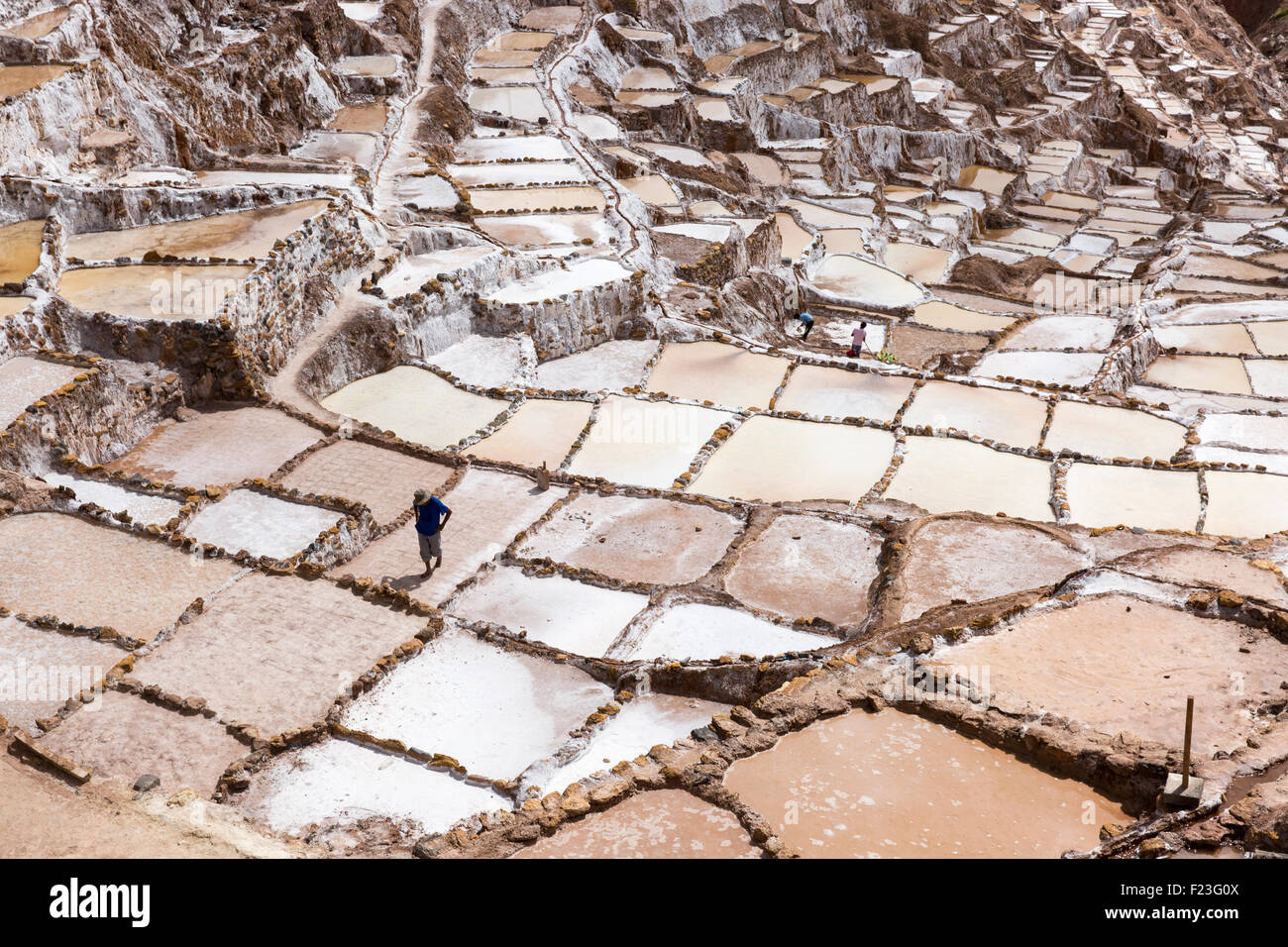 Peru, Maras, Worker walking among salt evaporation pools of Salineras ...