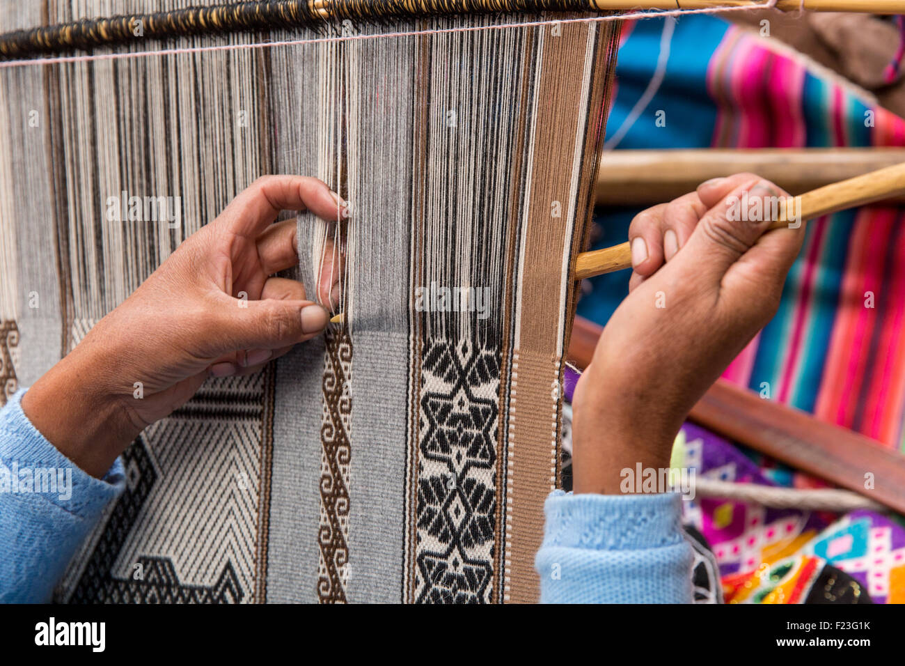 Peru, Cusco Region, Woman weaving using traditional loom outside gift ...