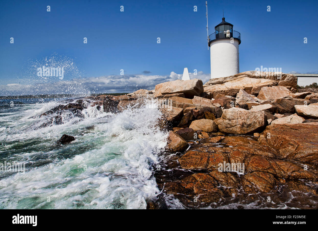 Waves crashing along the rocky shoreline with Goat Island Lighthouse ...
