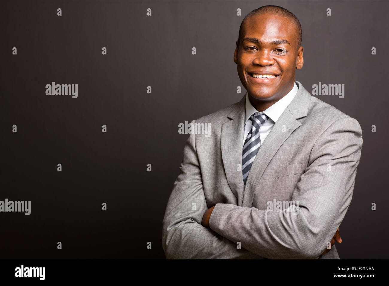 successful African business man with arms folded on black background ...