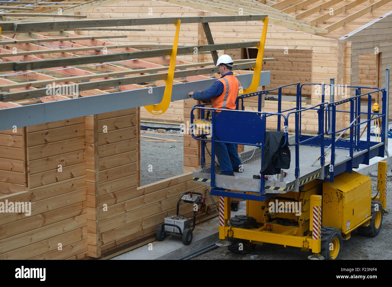 A builder installs a safety guard around the roof of a new building ...
