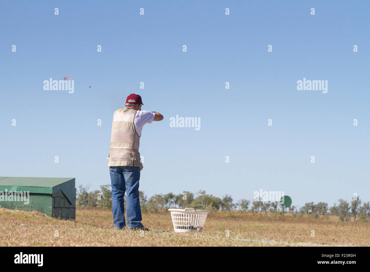 Clay target shooter aiming at the clay target, showing wad and shot ...