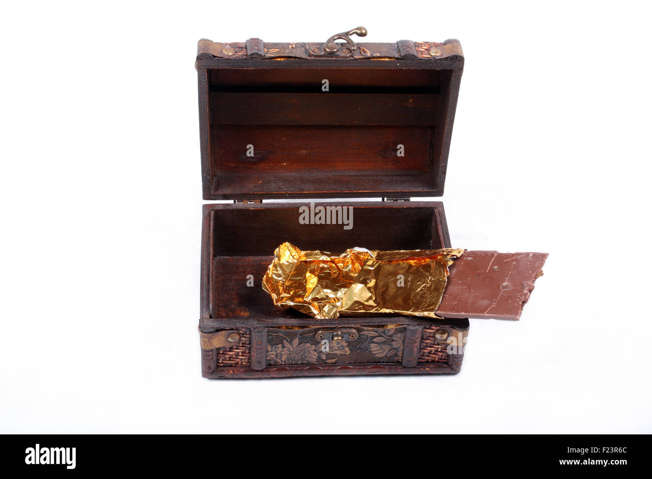 An antique wooden treasure box with a chocolate bar wrapped in golden ...