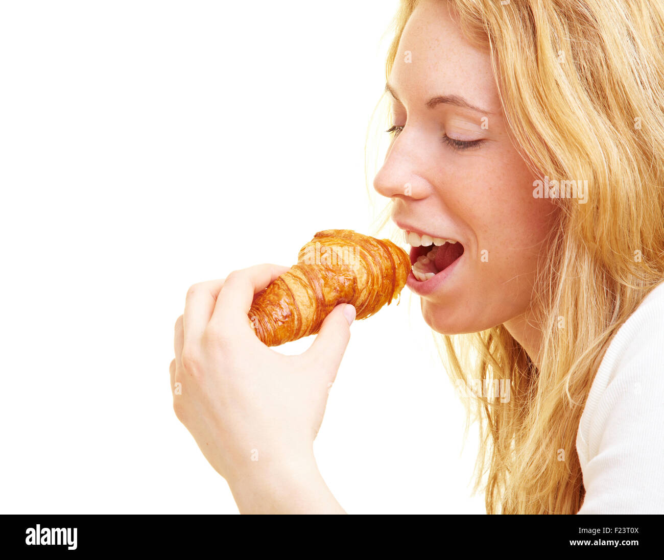 Happy woman eating a croissant at breakfast Stock Photo - Alamy