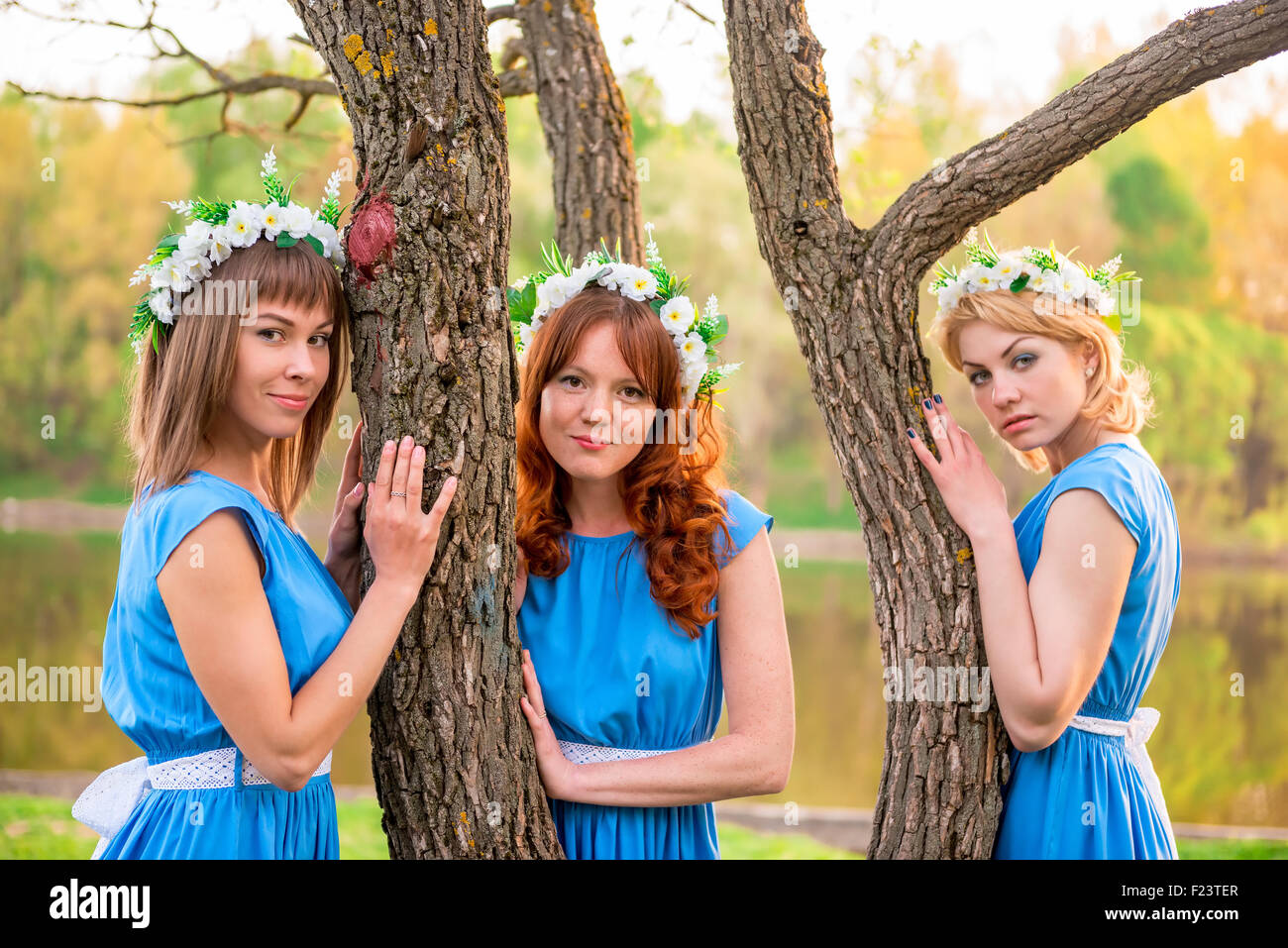 horizontal portrait of three friends near a tree Stock Photo - Alamy