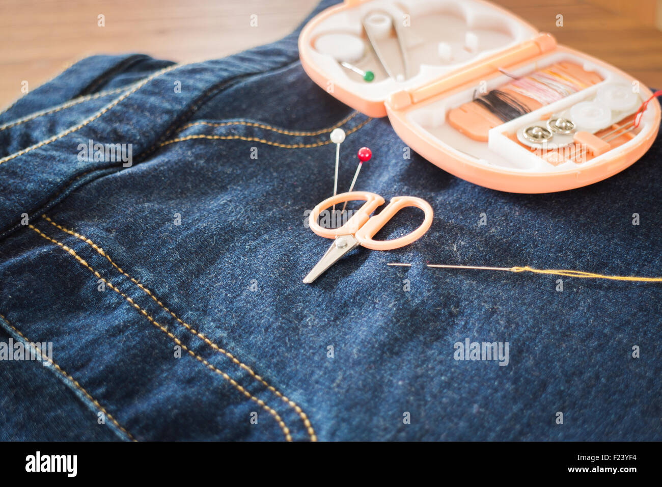 Needle with a thread through the jean, stock photo Stock Photo - Alamy