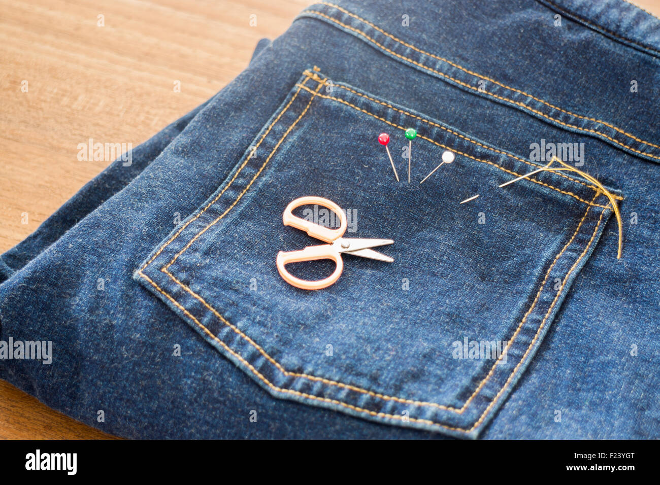 Needle with a thread through the jean, stock photo Stock Photo - Alamy
