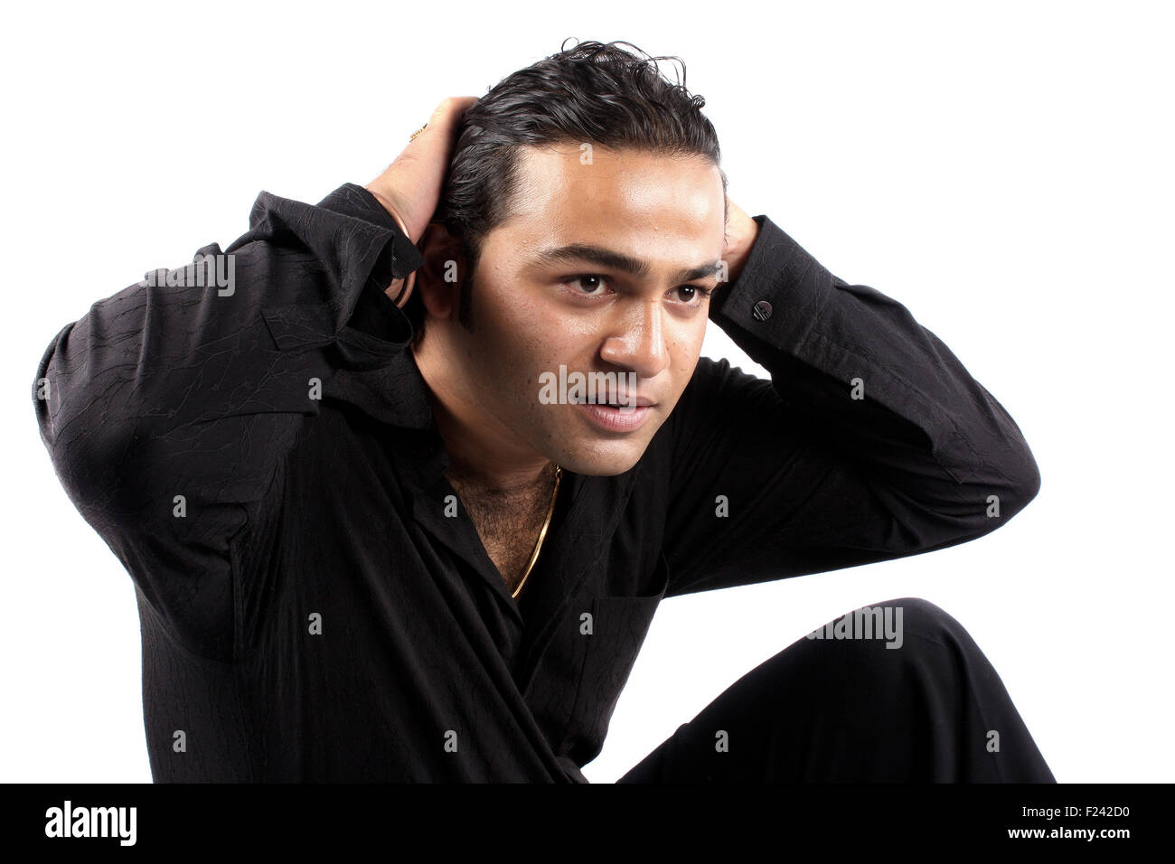 A young tired Indian model setting his hair, isolated on white studio ...