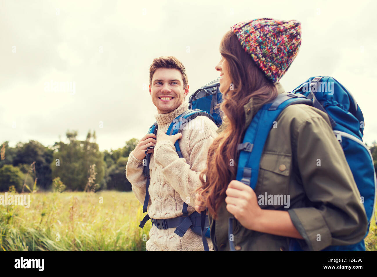 smiling couple with backpacks hiking Stock Photo - Alamy