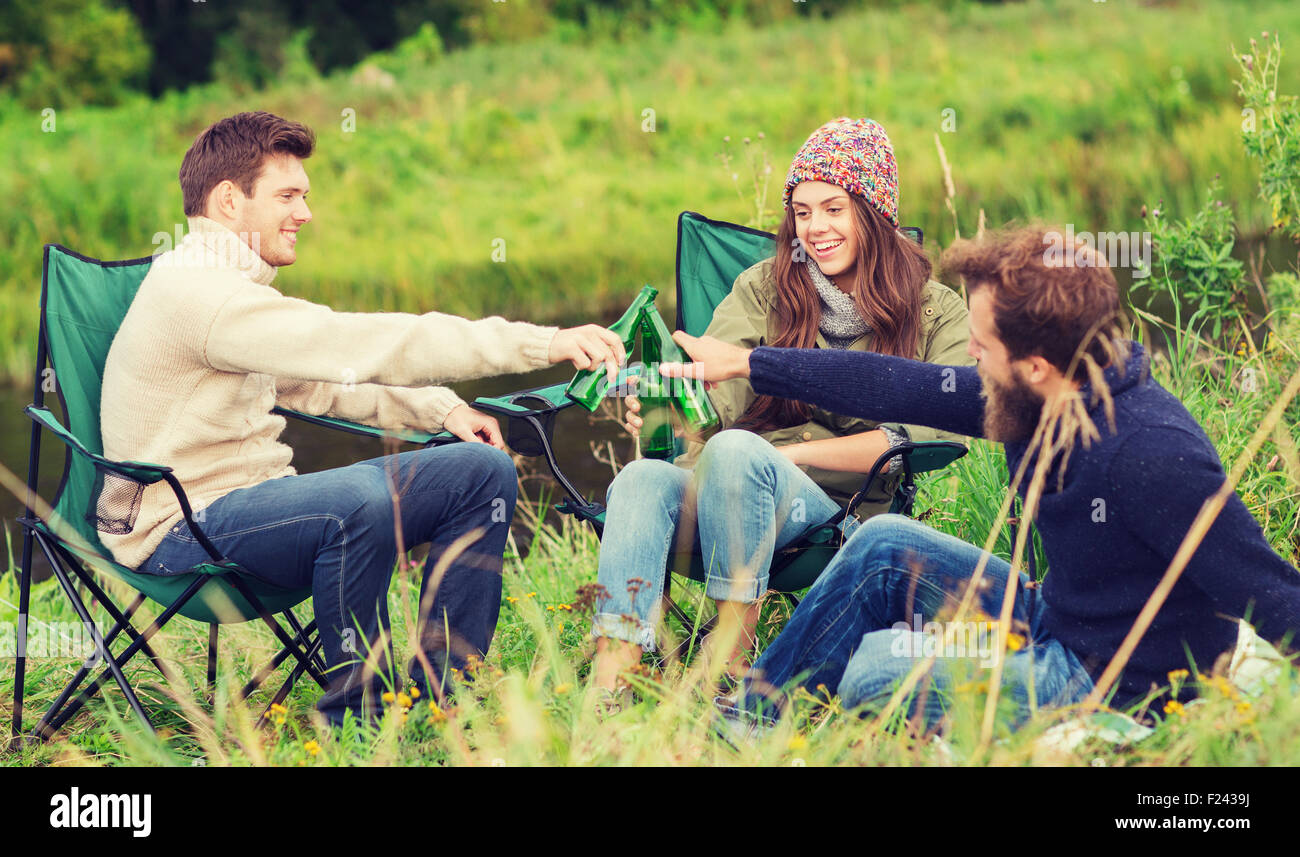 group of smiling tourists drinking beer in camping Stock Photo - Alamy
