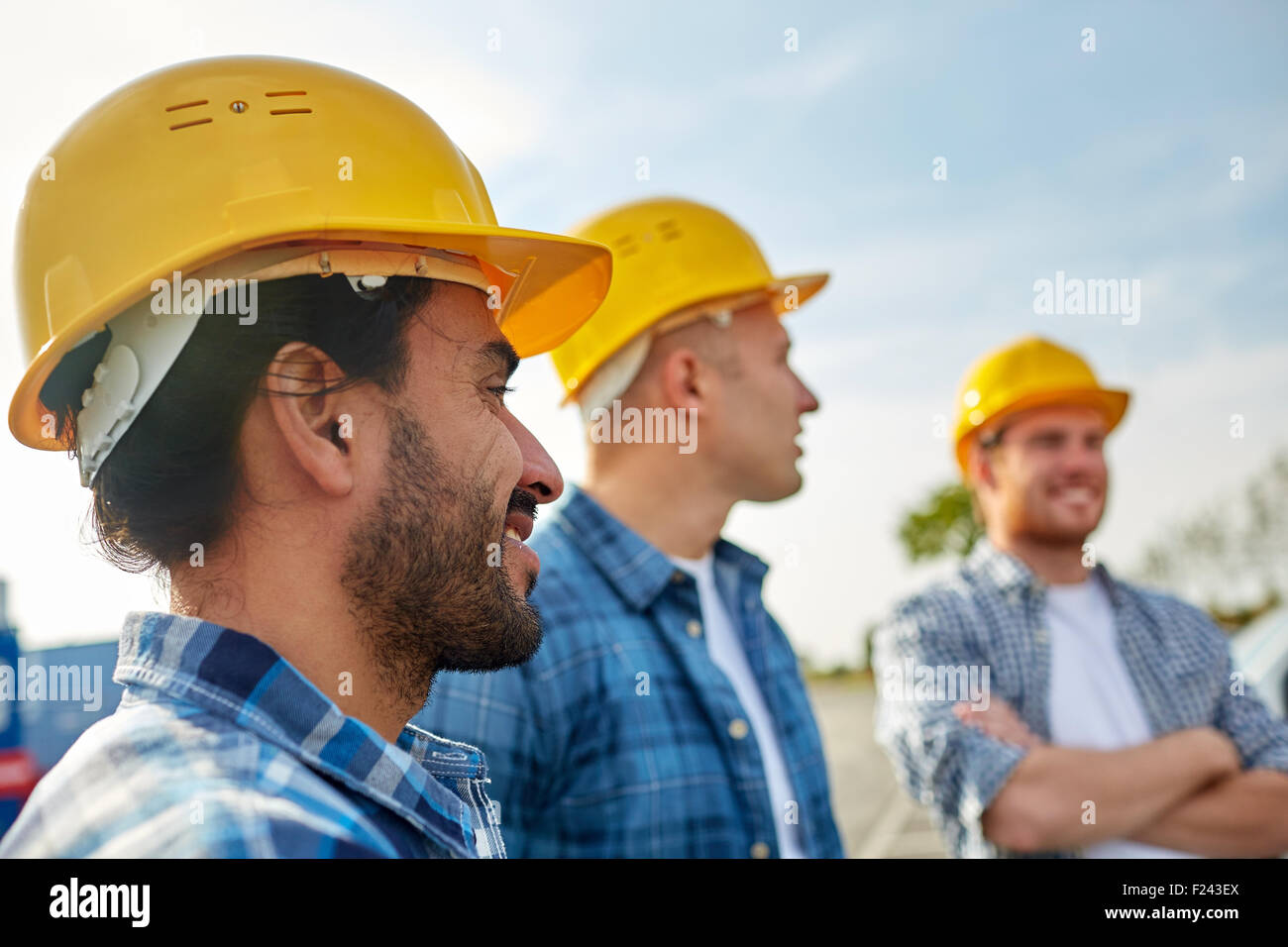 group of smiling builders in hardhats outdoors Stock Photo - Alamy