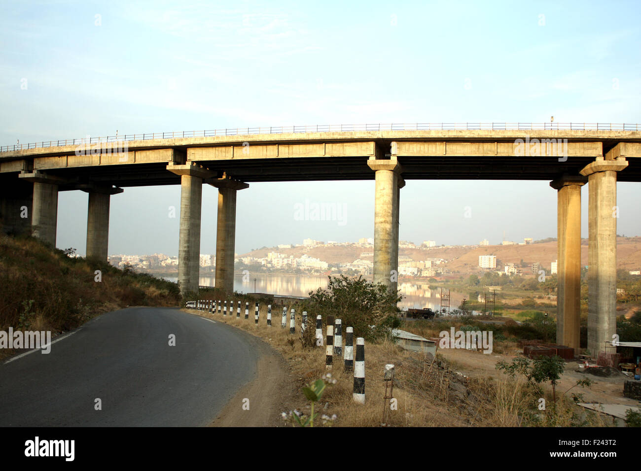 A tall concrete bridge going over a small road Stock Photo - Alamy