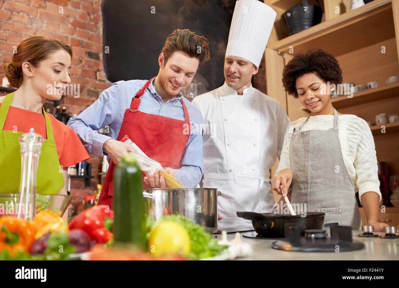 happy friends and chef cook cooking in kitchen Stock Photo - Alamy