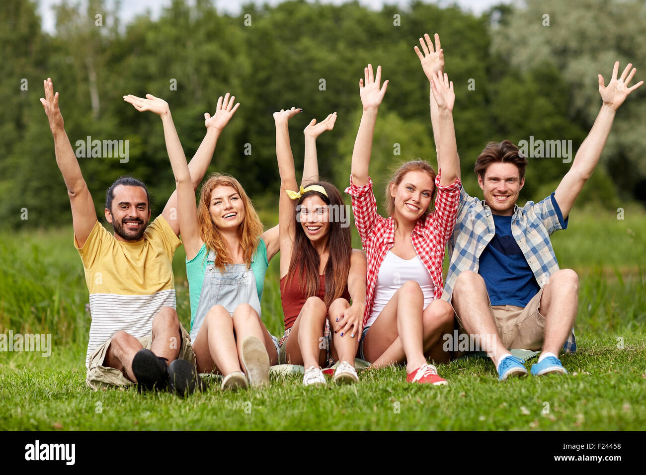 group of smiling friends waving hands outdoors Stock Photo - Alamy