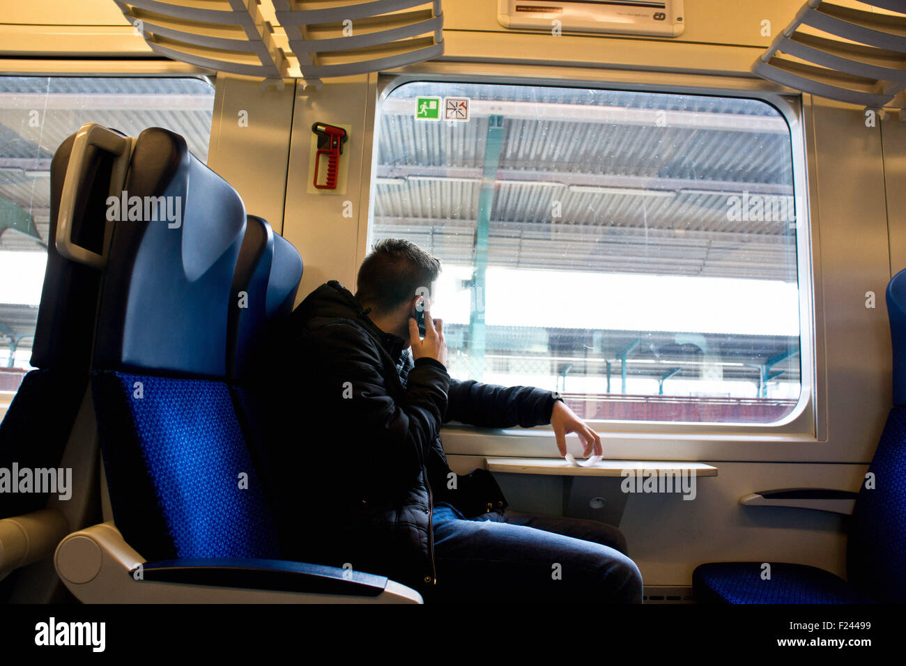 young man in a train talking on cellphone Stock Photo - Alamy