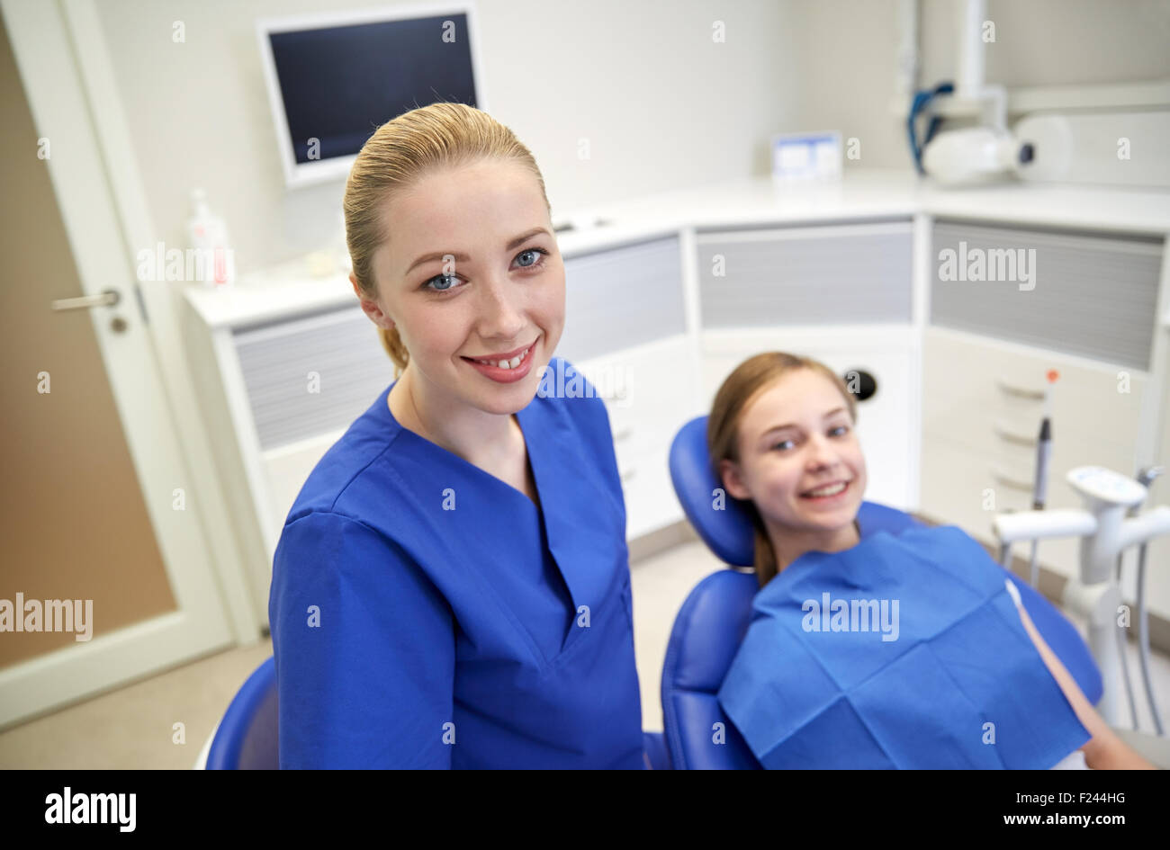happy female dentist with patient girl at clinic Stock Photo - Alamy