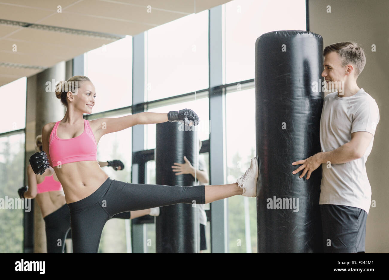 smiling woman with personal trainer boxing in gym Stock Photo - Alamy