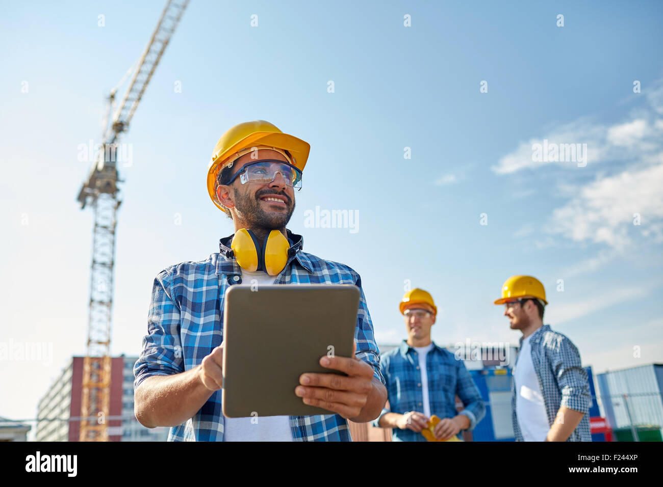 builder in hardhat with tablet pc at construction Stock Photo - Alamy