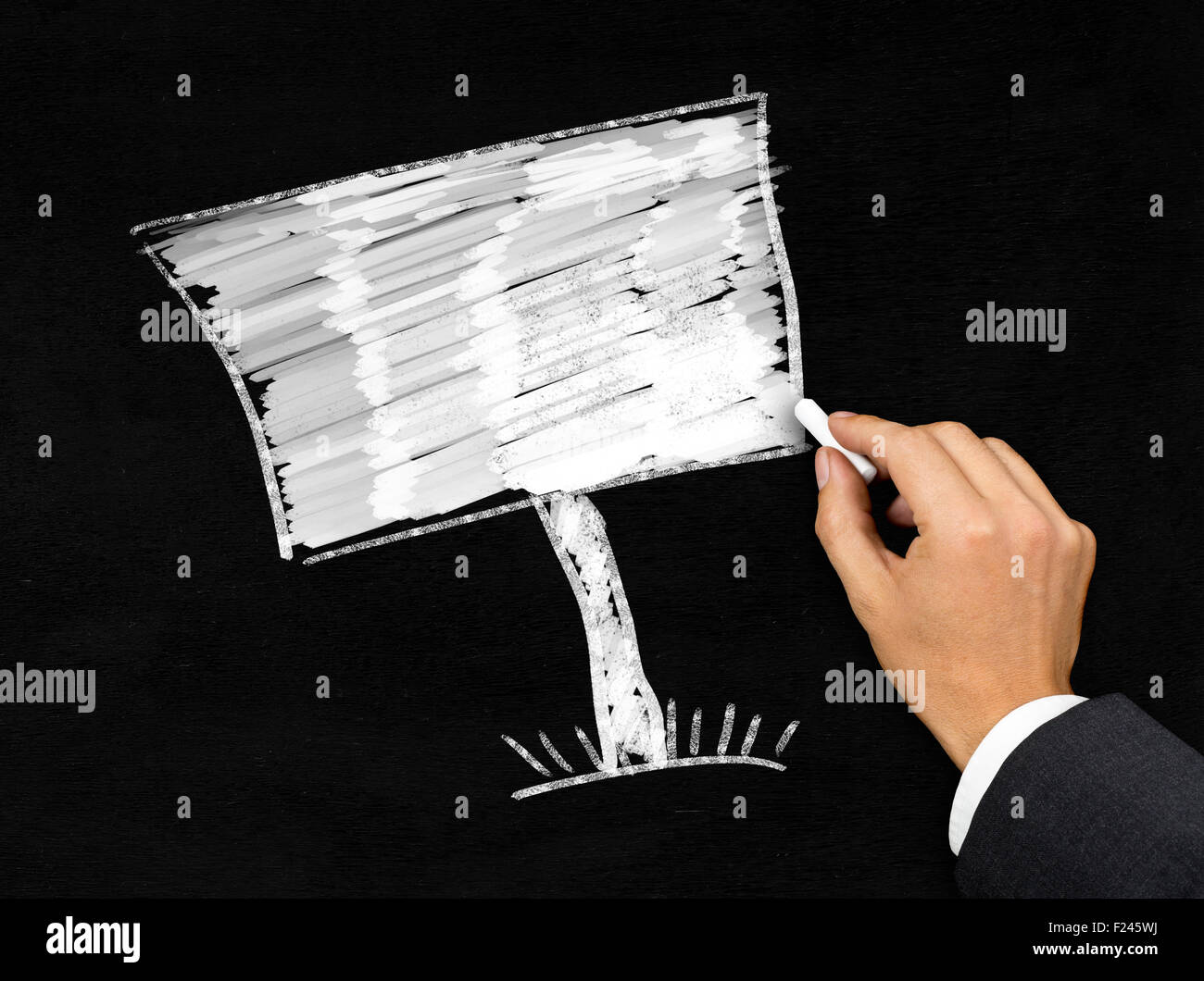 Man drawing empty sign with copy space with chalk on blackboard ...